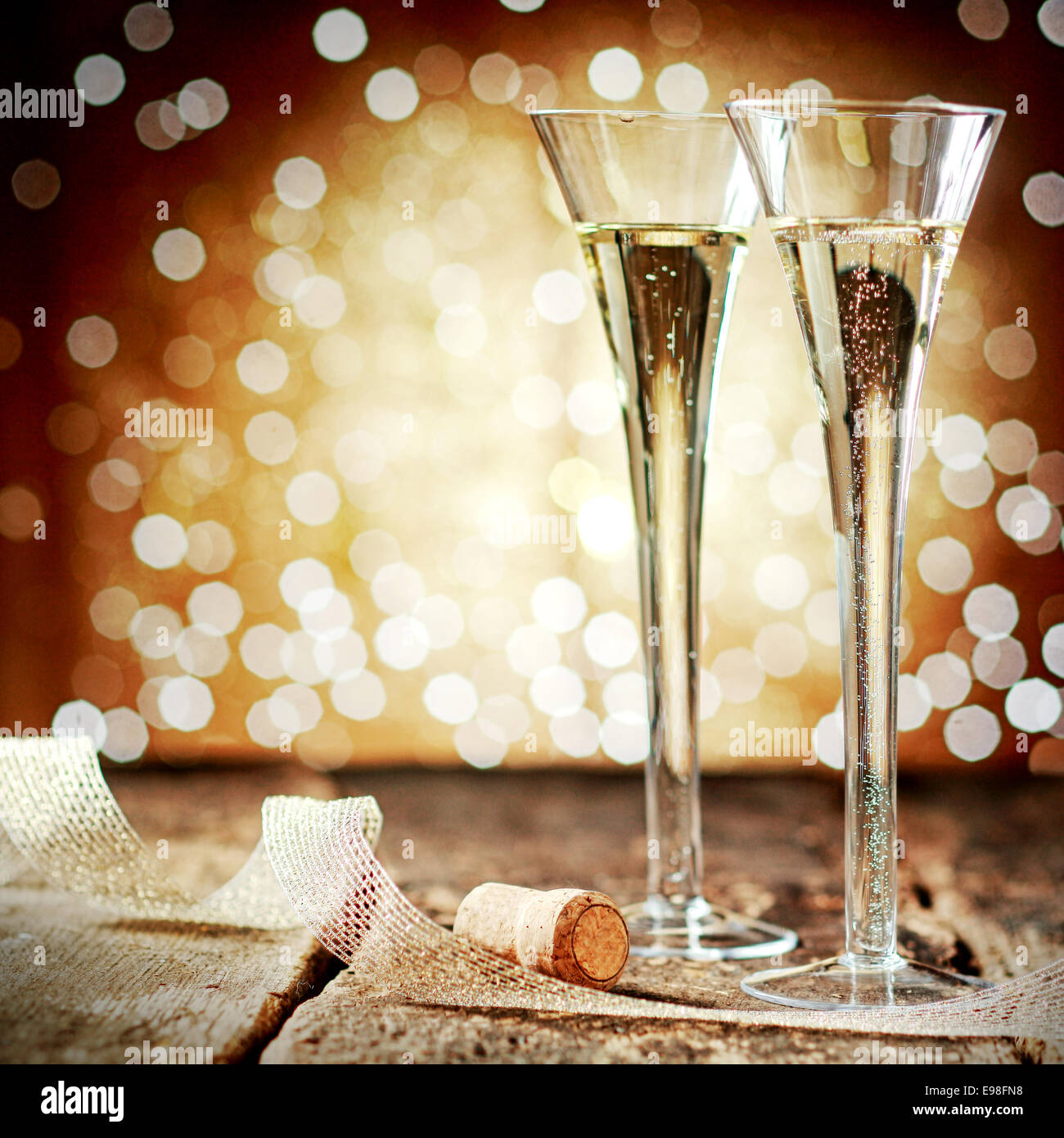 Two elegant flutes of sparkling golden champagne with twirled ...
