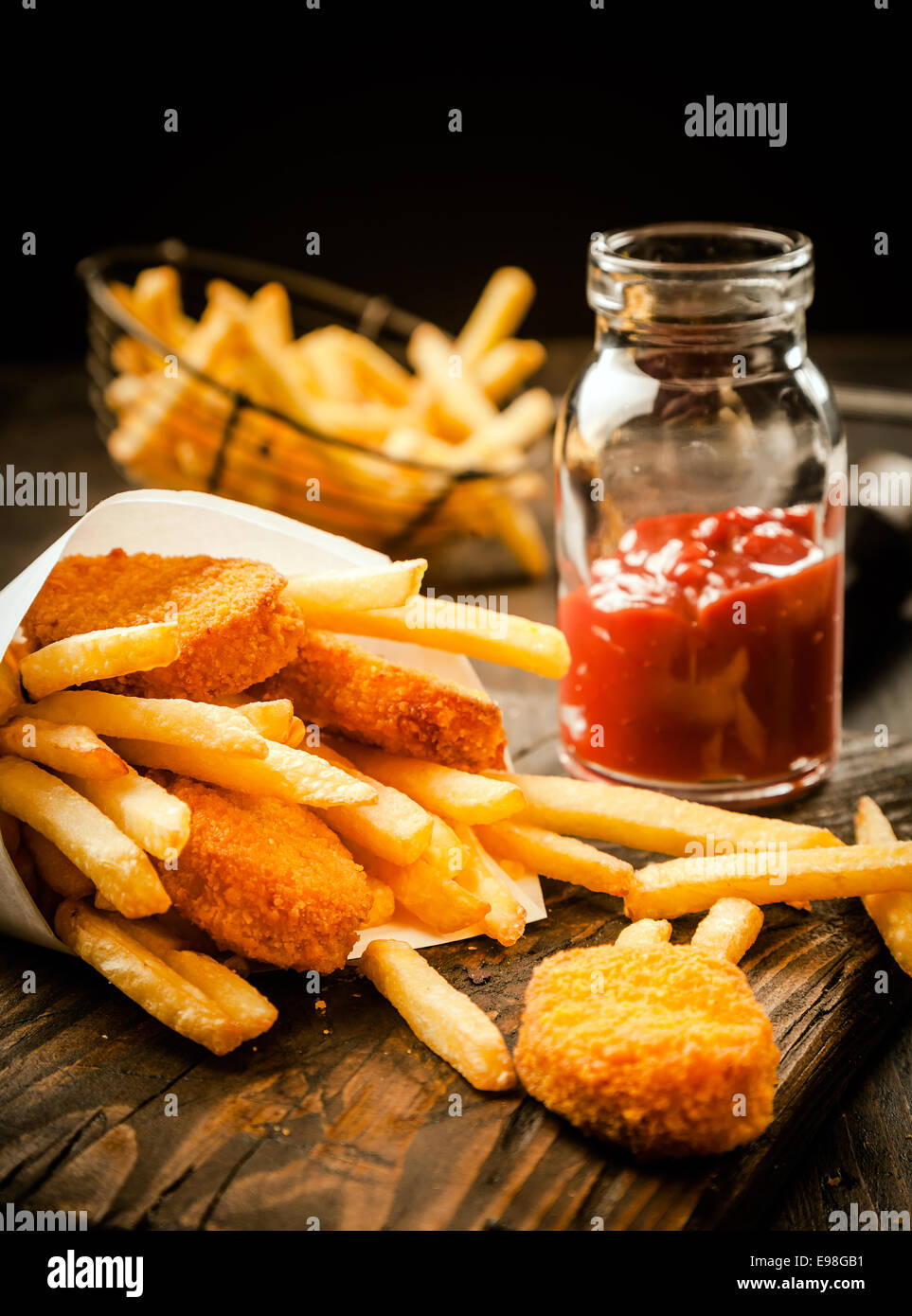 Crisp golden battered fried fish portions served with potato chips in a ...