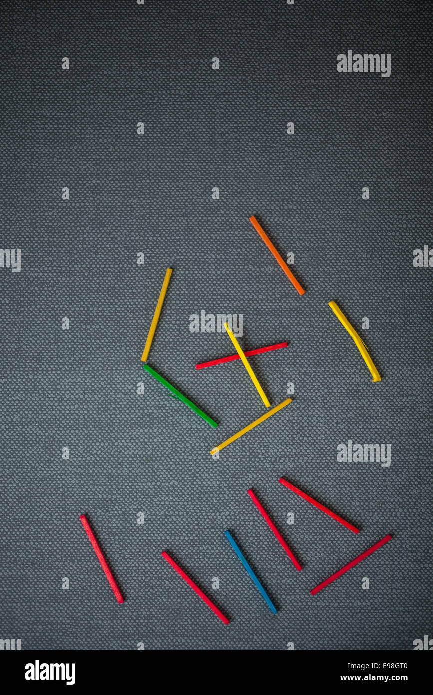 Collection of pick-up sticks game scattered across fabric tabeltop ...