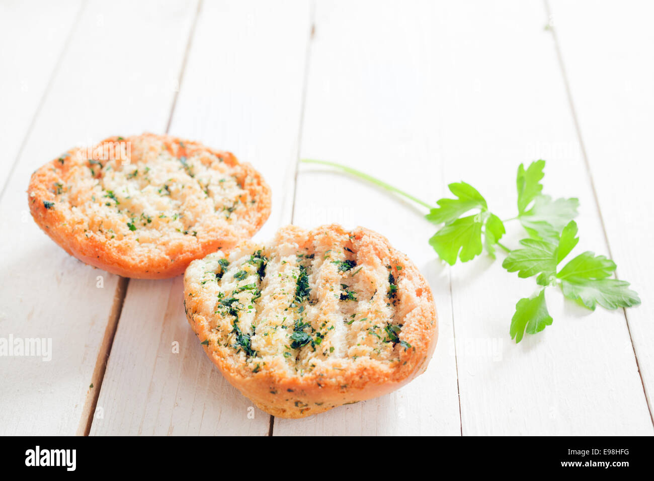 Delicious grilled golden crisp herb bread with fresh parsley on a white ...
