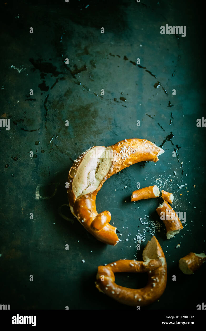 Remnants of a broken crisp salted savory pretzel broken into pieces ...