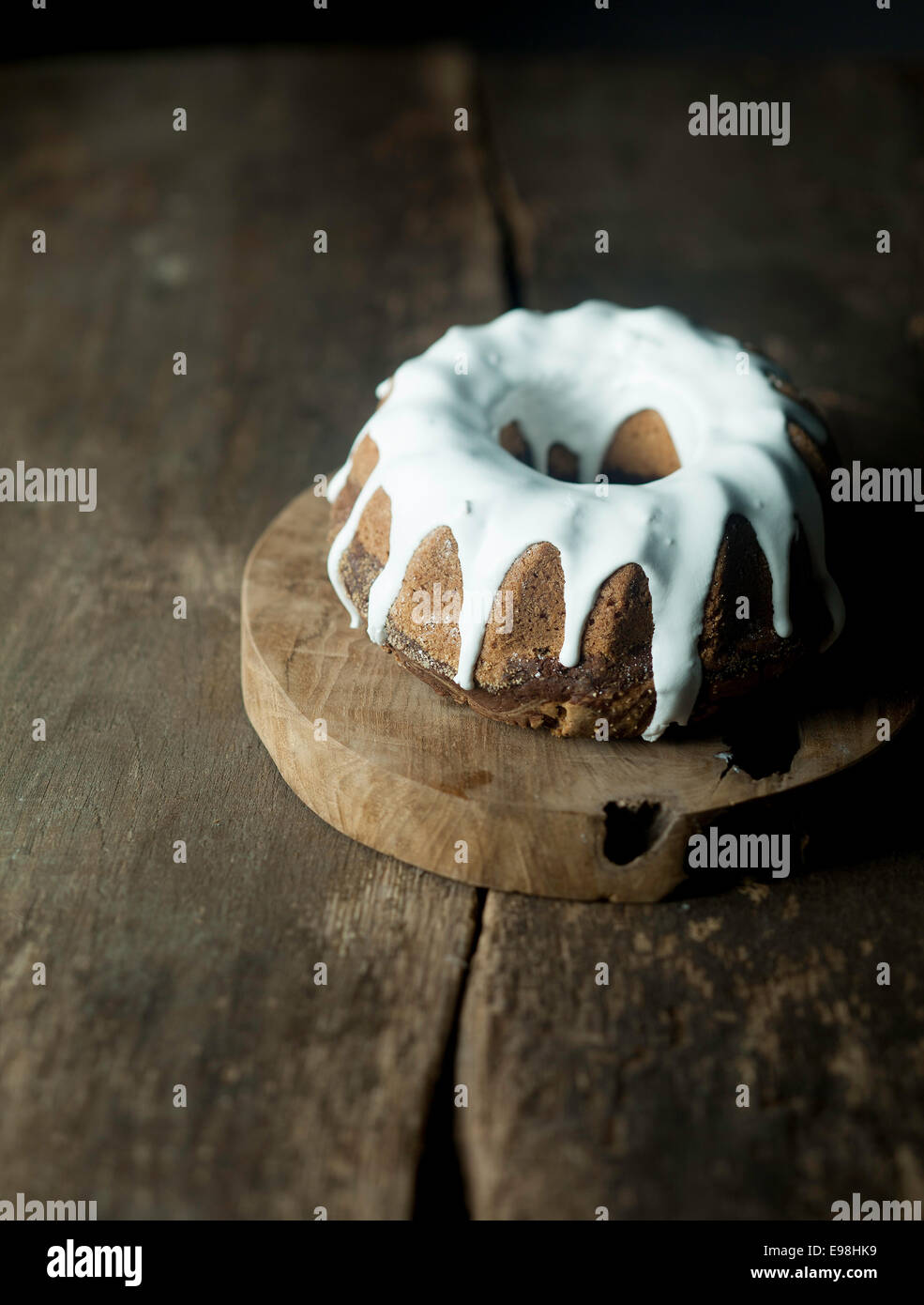 Freshly baked marble ring cake with tangy lemon icing displayed on a ...