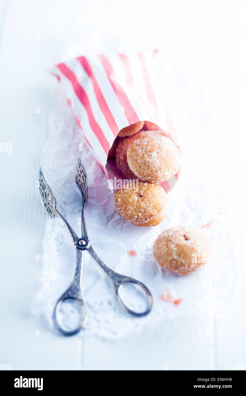 Striped red and white packet of mini sugared doughnuts spilling onto a ...