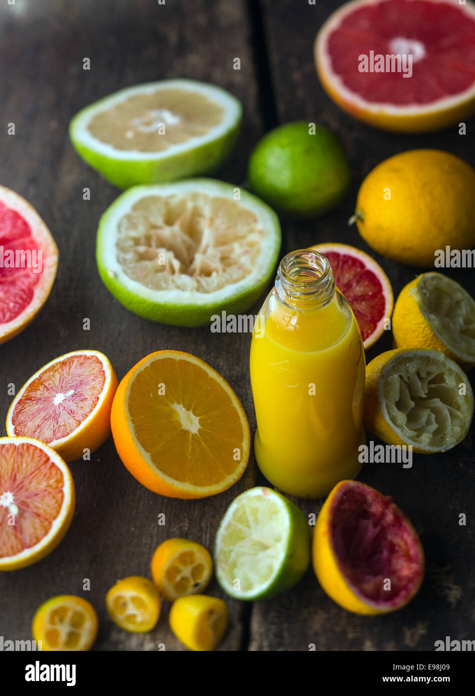 Preparing fresh citrus juice in a rustic kitchen with a bottle of ...