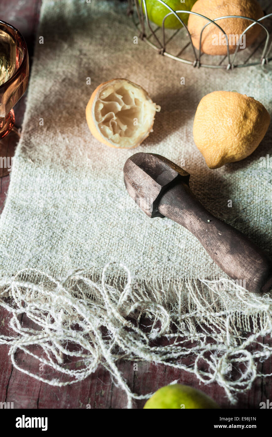Juicing lemons with a vintage wooden reamer in a rustic kitchen Stock ...