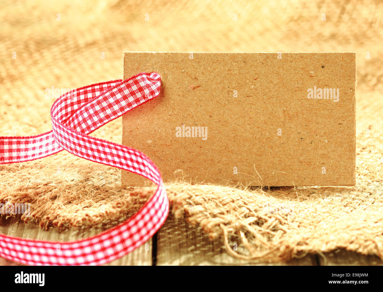 Blank brown tag with copyspace tied with a fresh red and white rustic ...
