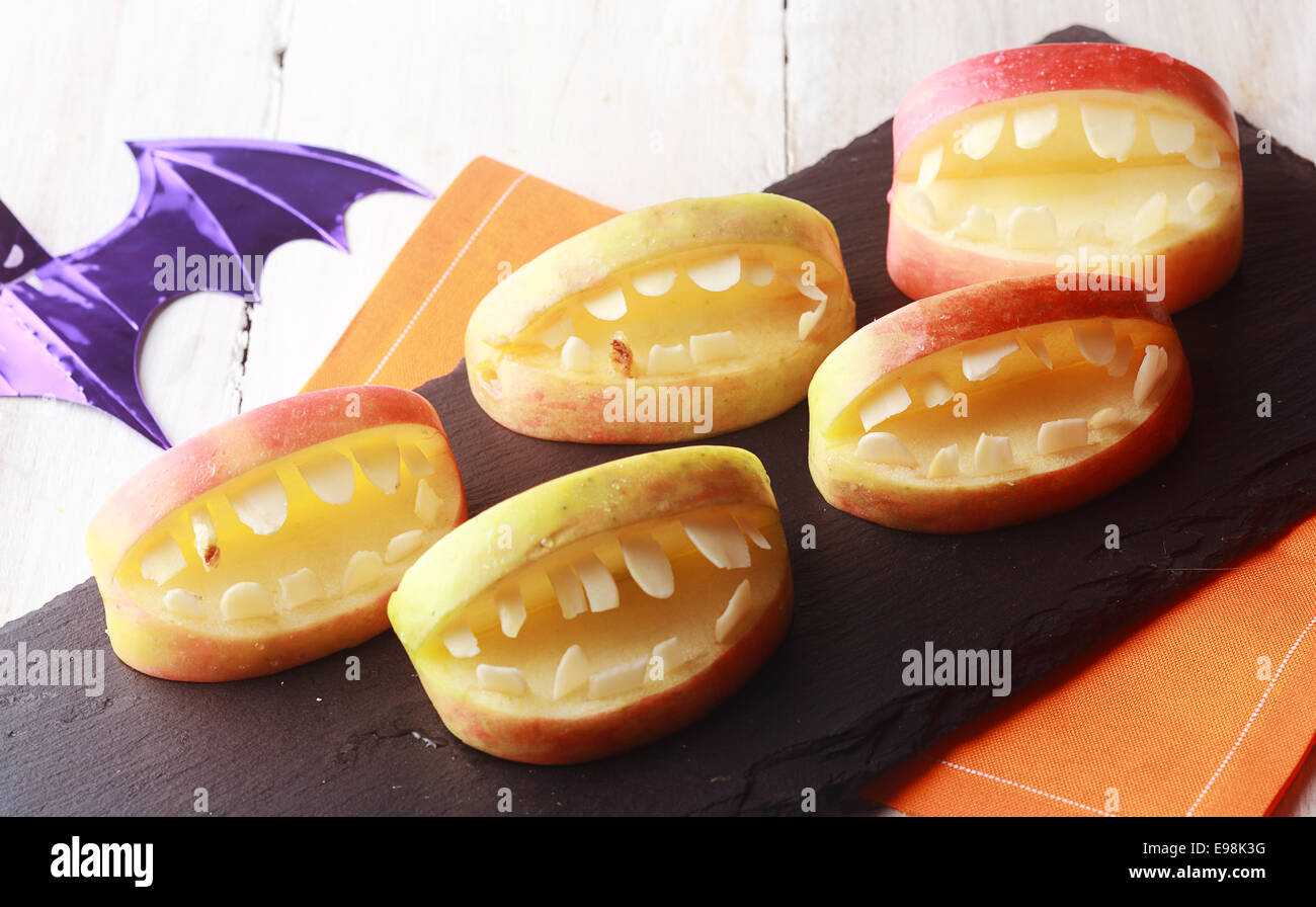Scary Halloween apples with cutout teeth in an open mouth for a healthy ...
