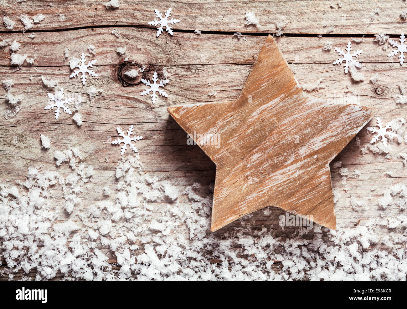 Handmade rustic wooden Christmas star with scattered snowflakes on an ...