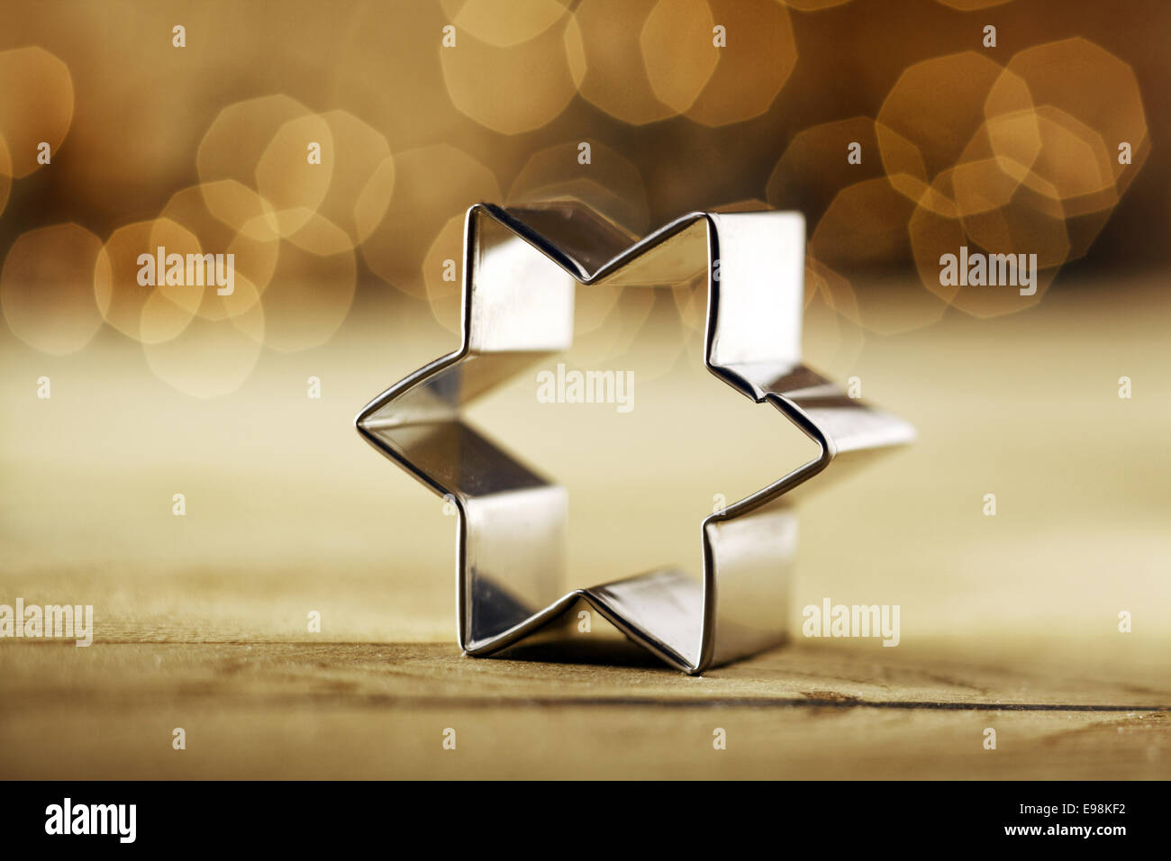 Close-up of a metallic star baking shape on a table with Christmas ...