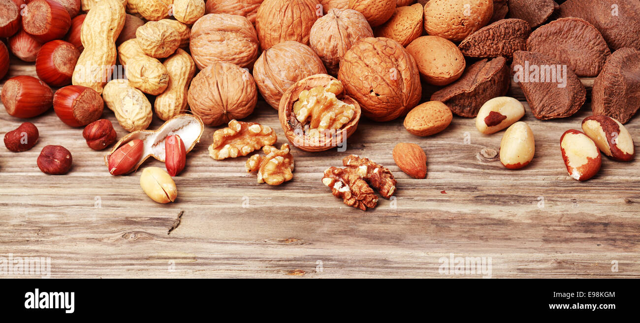 Variety of shelled and whole nuts in a horizontal banner including ...