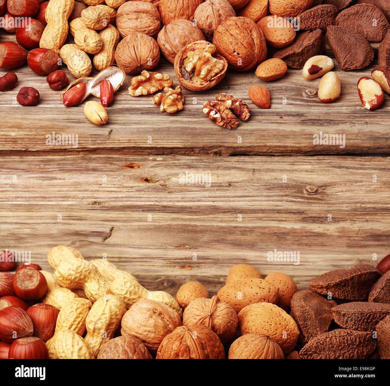 Double border of assorted fresh nuts both in their shells and shelled ...