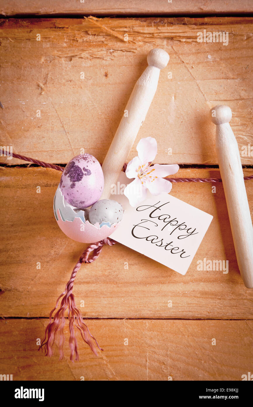 Label with handwritten Happy Easter hanging from rustic wooden pegs ...