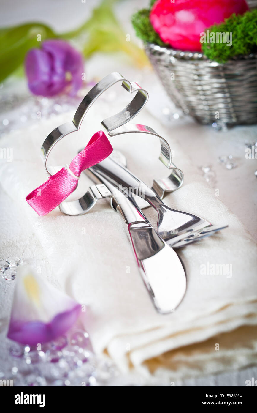 Shiny silver metal Easter Bunny decorated with a bow together with a ...