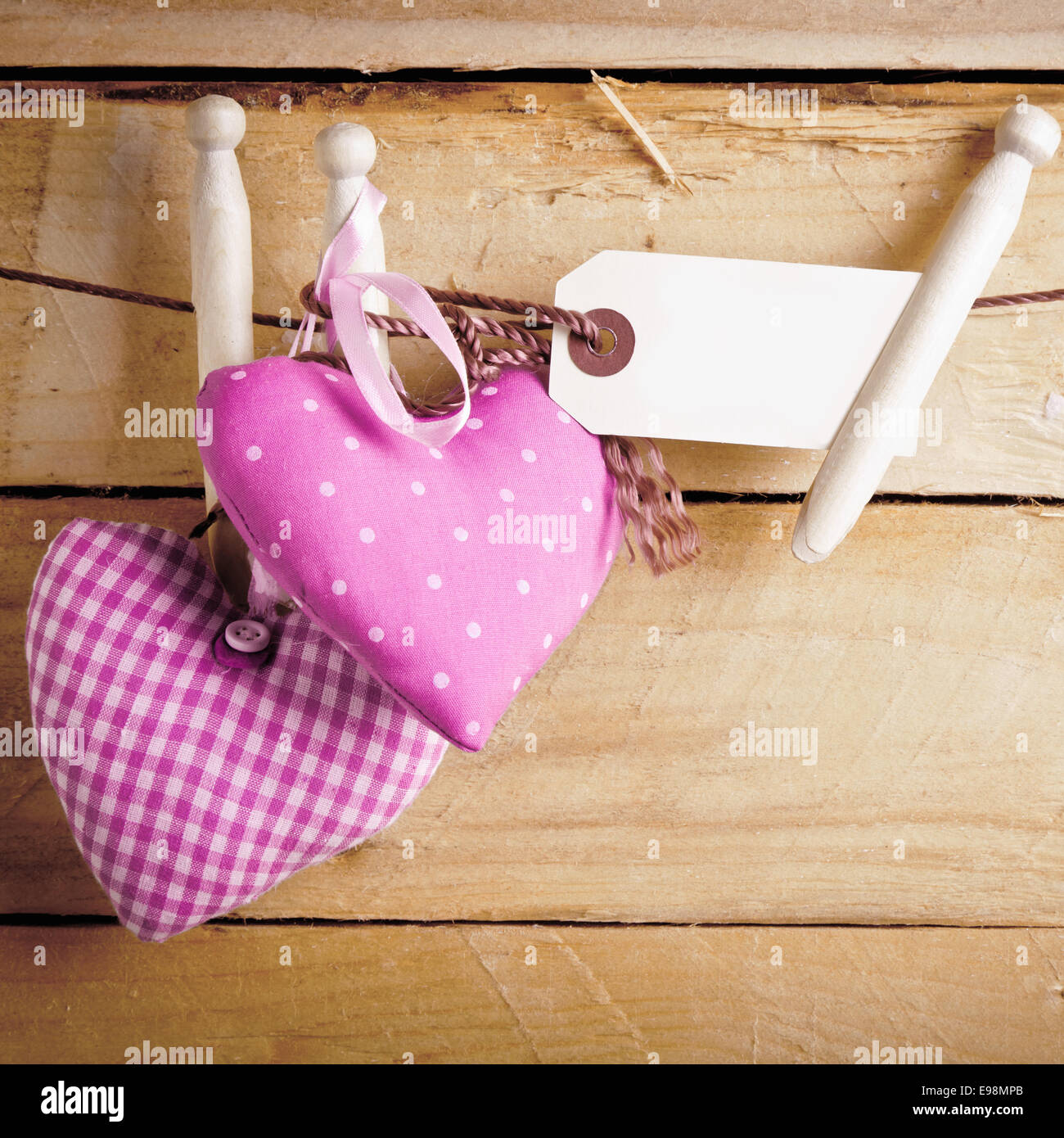Two romantic pink patterned textile hearts hanging from rustic wooden ...