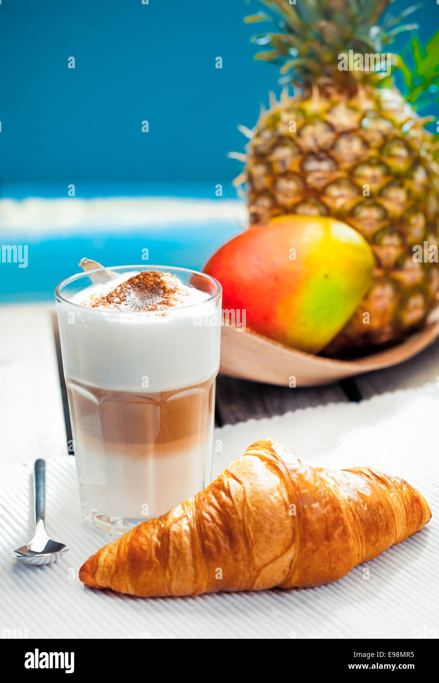 Healthy tropical snack of a crisp buttery croissant served with a ...