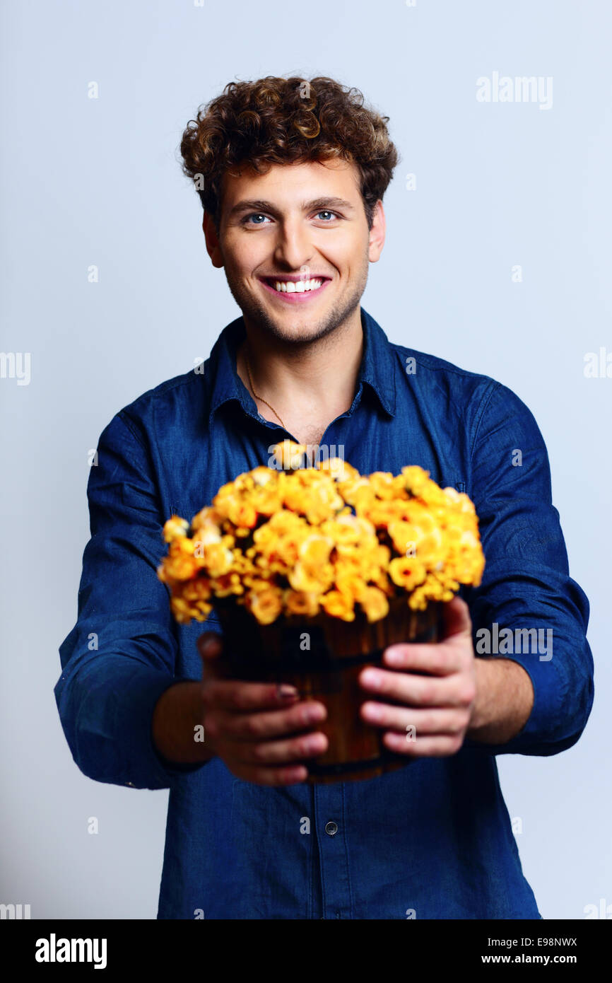 Happy man holding bucket with flowers Stock Photo - Alamy