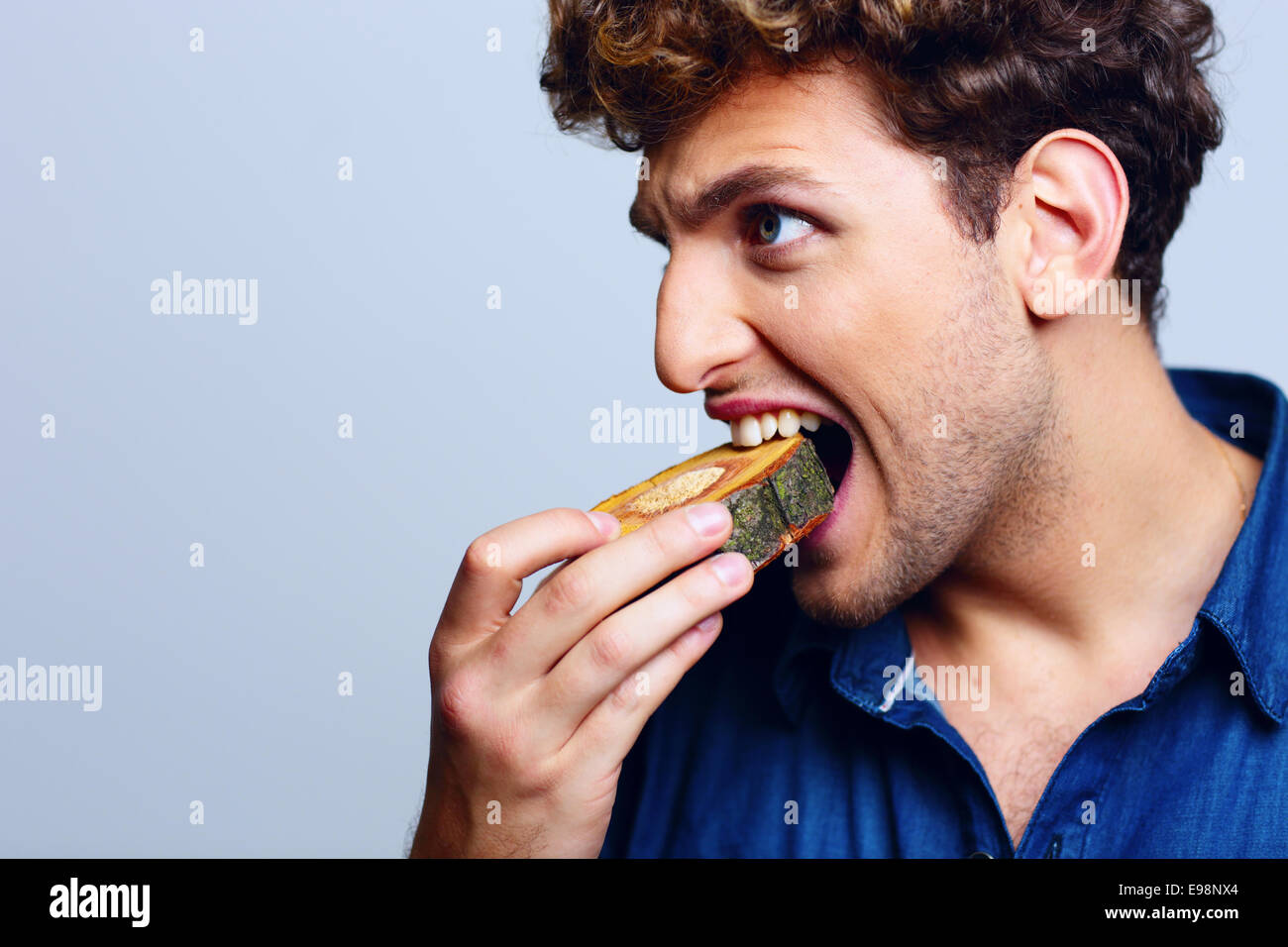Portrait of man biting wood circles Stock Photo - Alamy