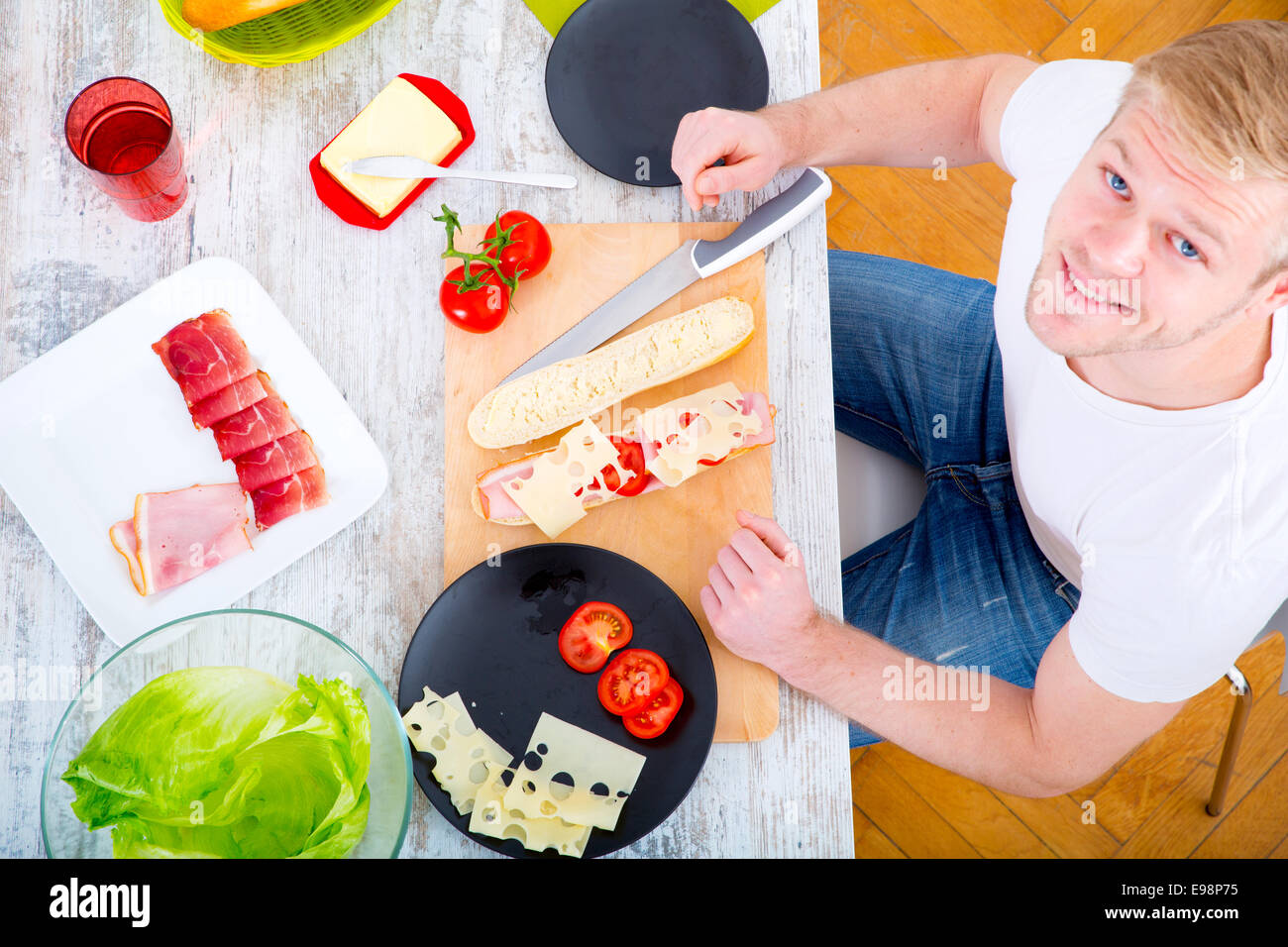 A young man preparing a sandwich in the kitchen Stock Photo - Alamy