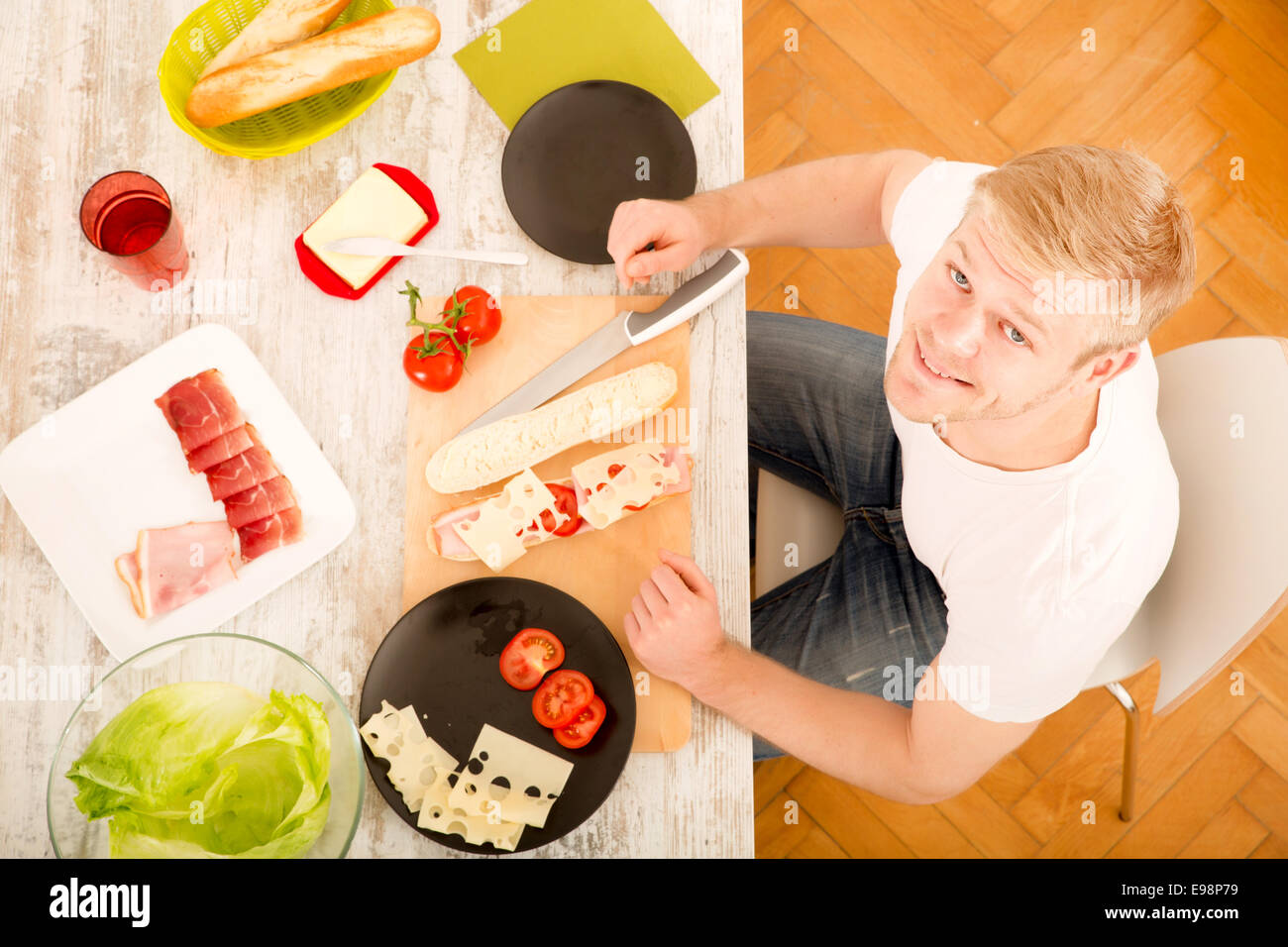 A young man preparing a sandwich in the kitchen Stock Photo - Alamy
