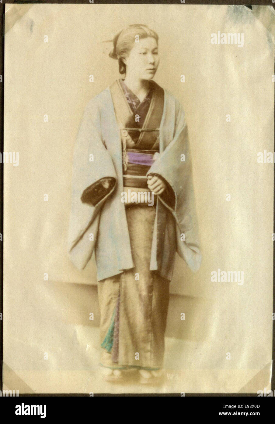 This hand-colored vintage photograph shows a woman in traditional ...