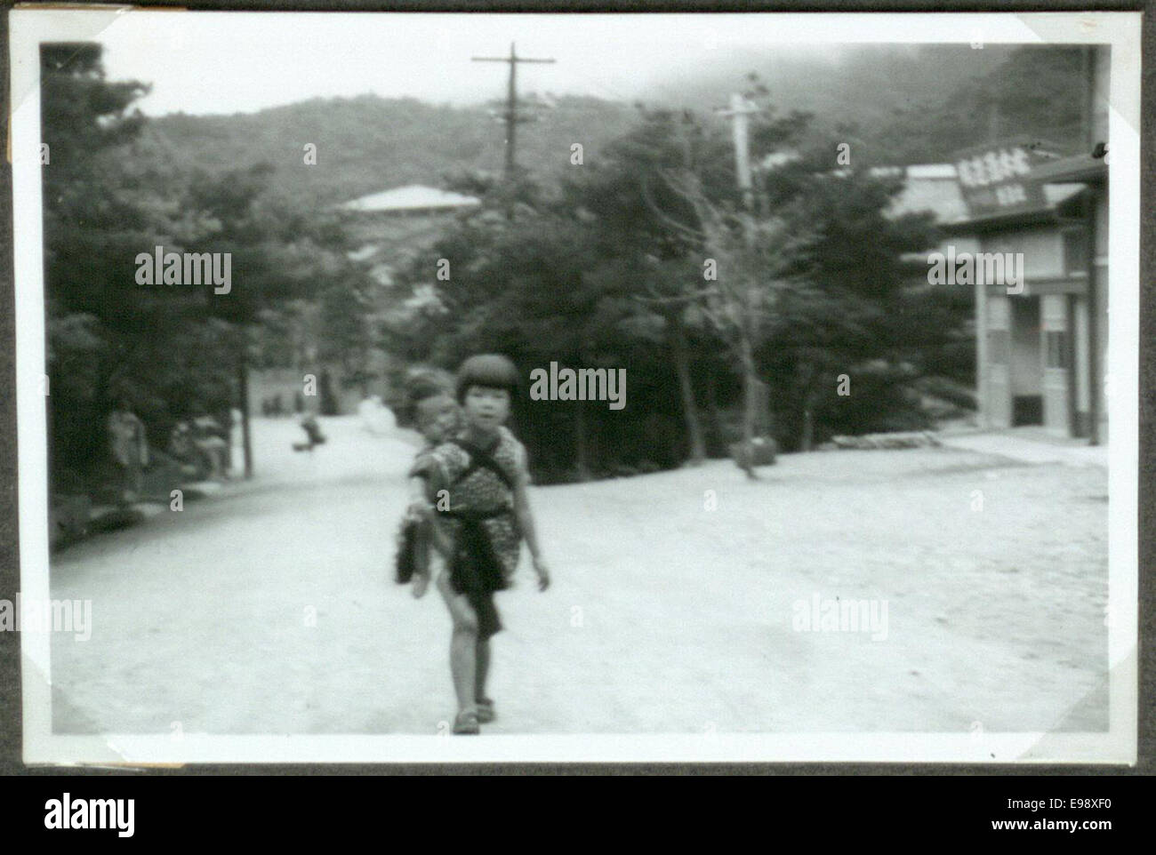 A photograph of a little girl in Japan carrying a child on her back ...