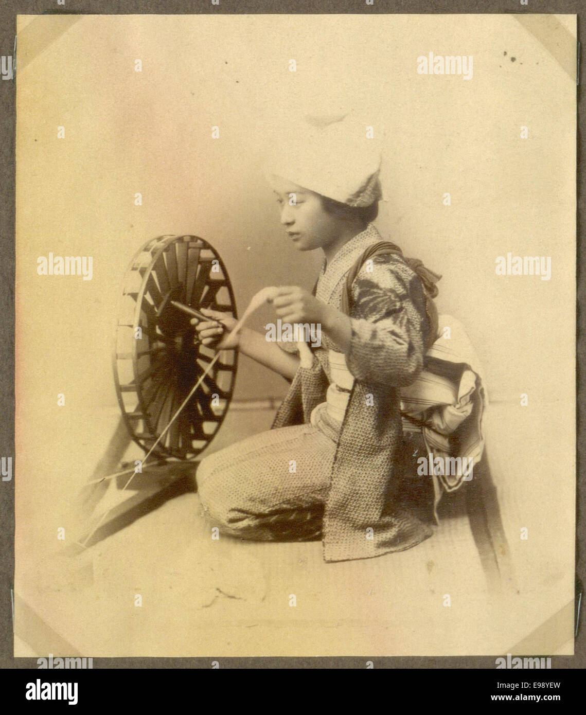 A photograph of a Japanese woman spinning thread, captured in a ...
