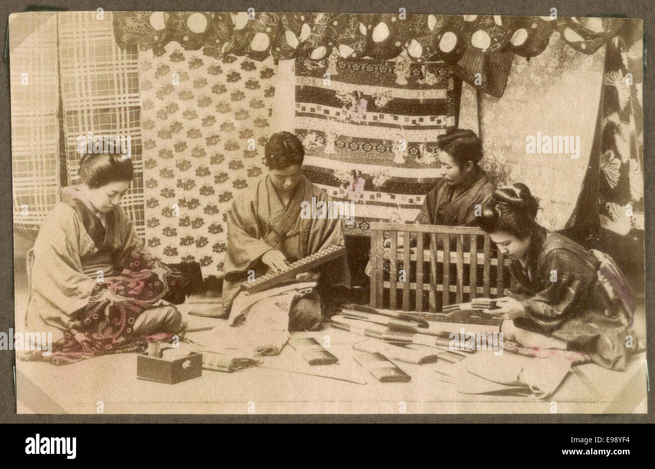 This image shows Japanese workmen engaged in traditional embroidery ...