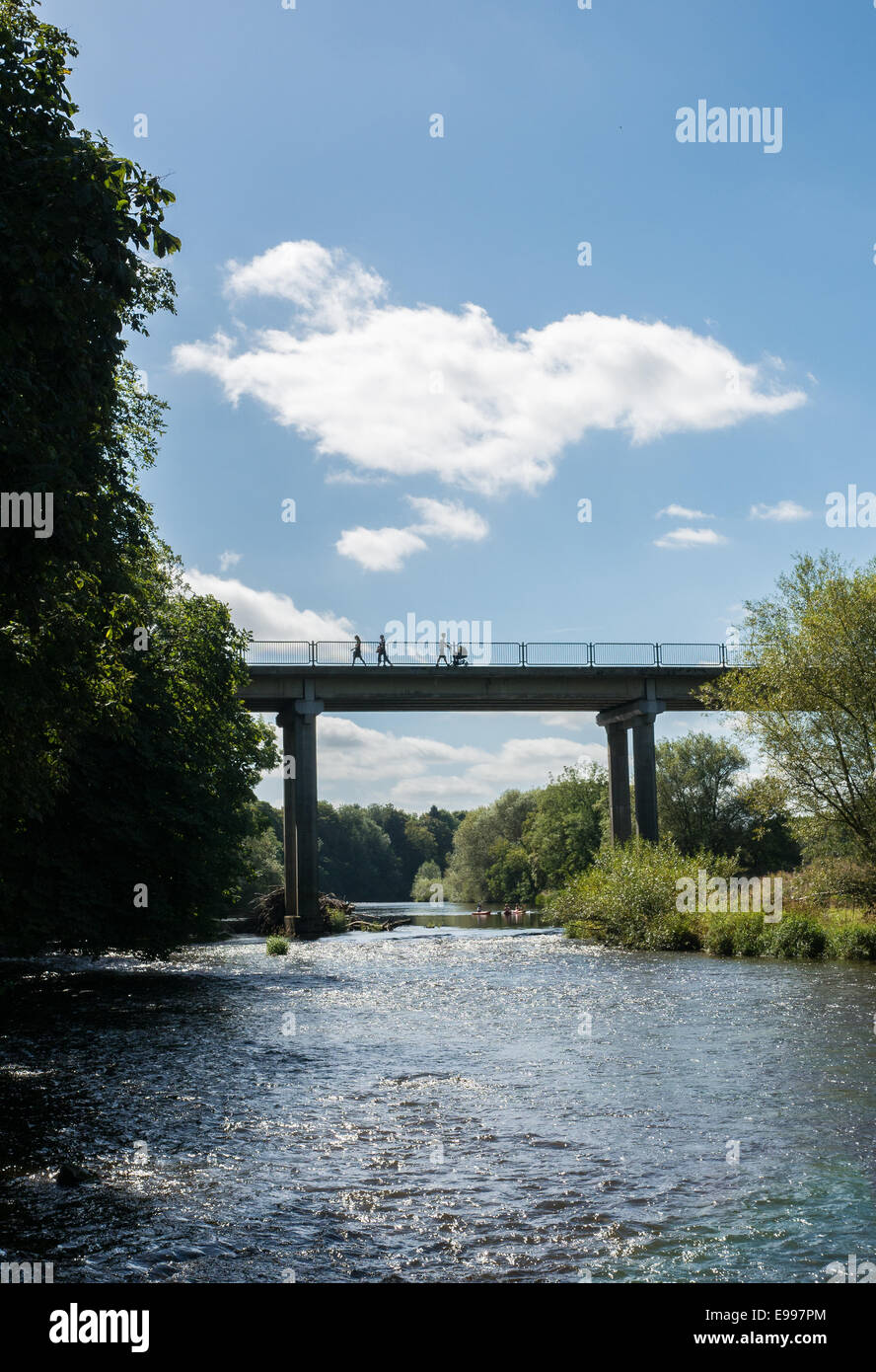 Pedestrians walk across the bridge over the river River Wye At Hay ...