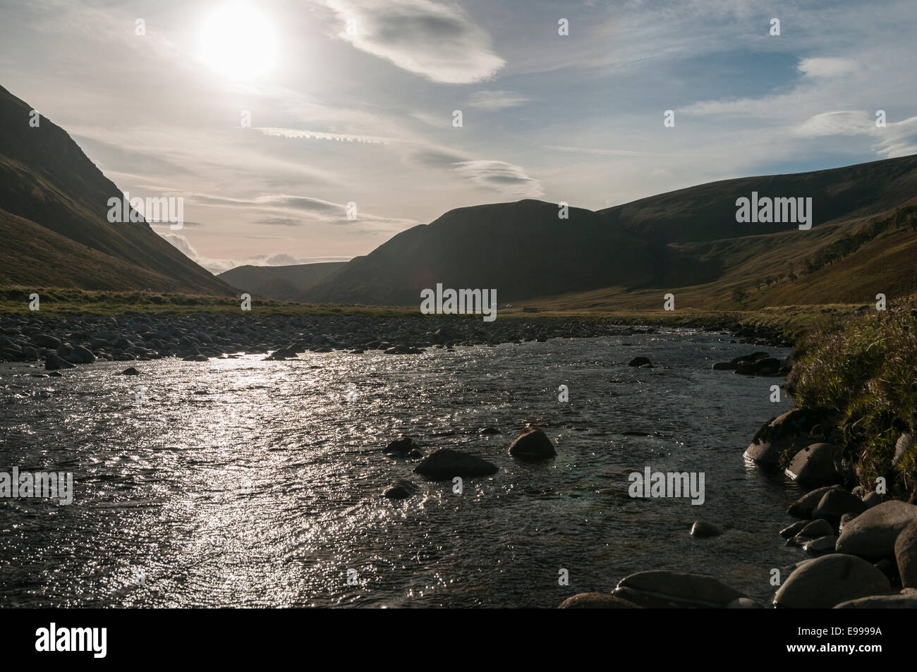 A photograph, upstream, of the sun reflecting on the river Findhorn ...