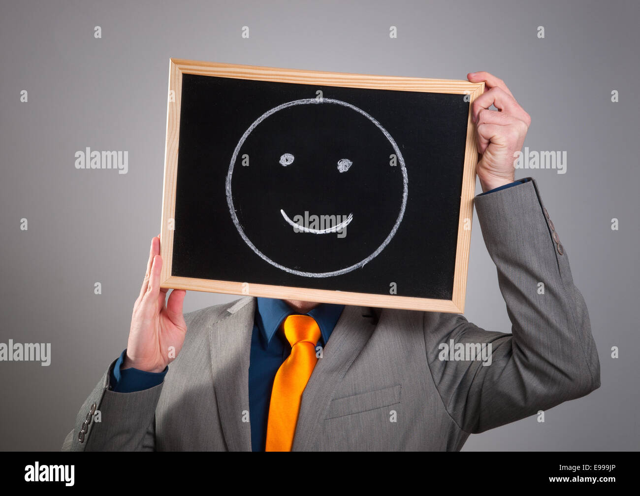 Businessman hiding his face with a white billboard with a smiley face ...