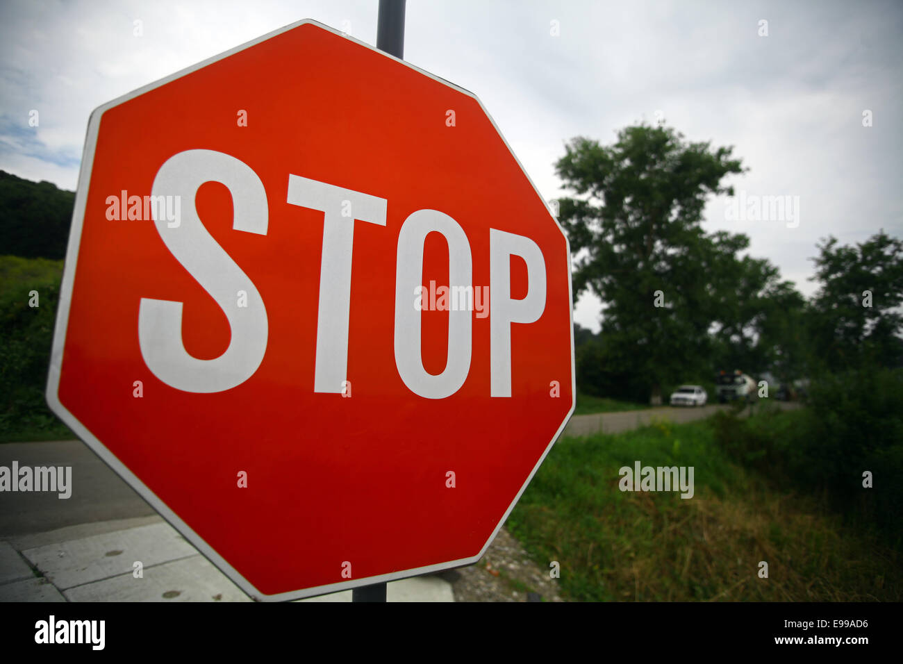 Color detail of a red "STOP" sign at a road junction Stock Photo - Alamy