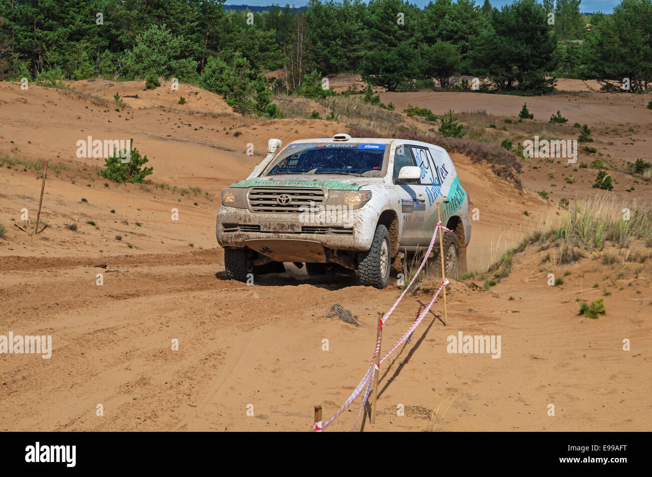Races on a rally-raid on sandy dunes. Racing car number 210 Stock Photo ...