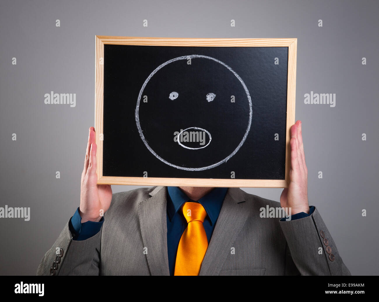 Businessman hiding his face with a white billboard with a surprised ...