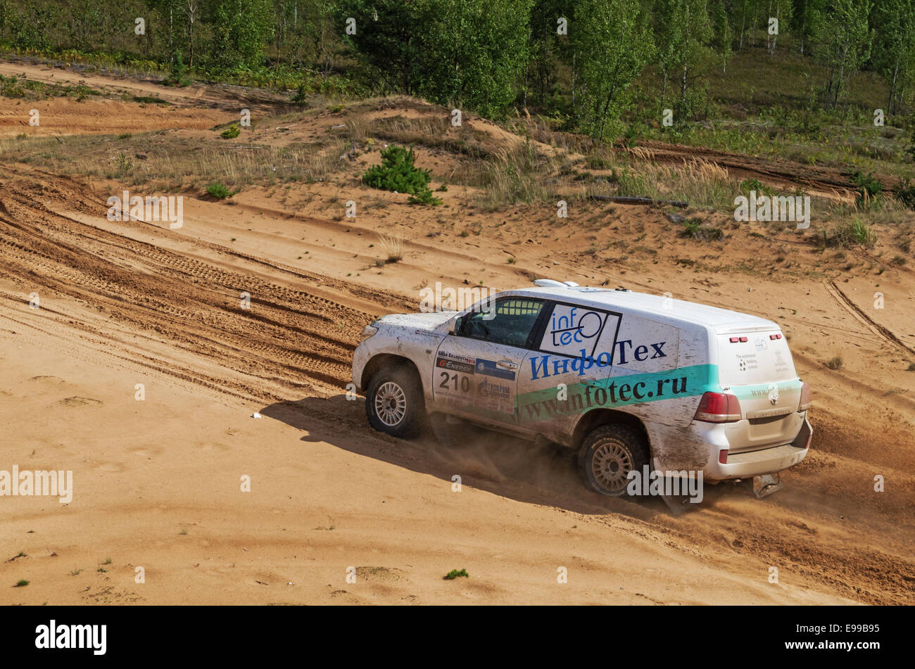 Races on a rally-raid on sandy dunes. Racing car number 210 Stock Photo ...