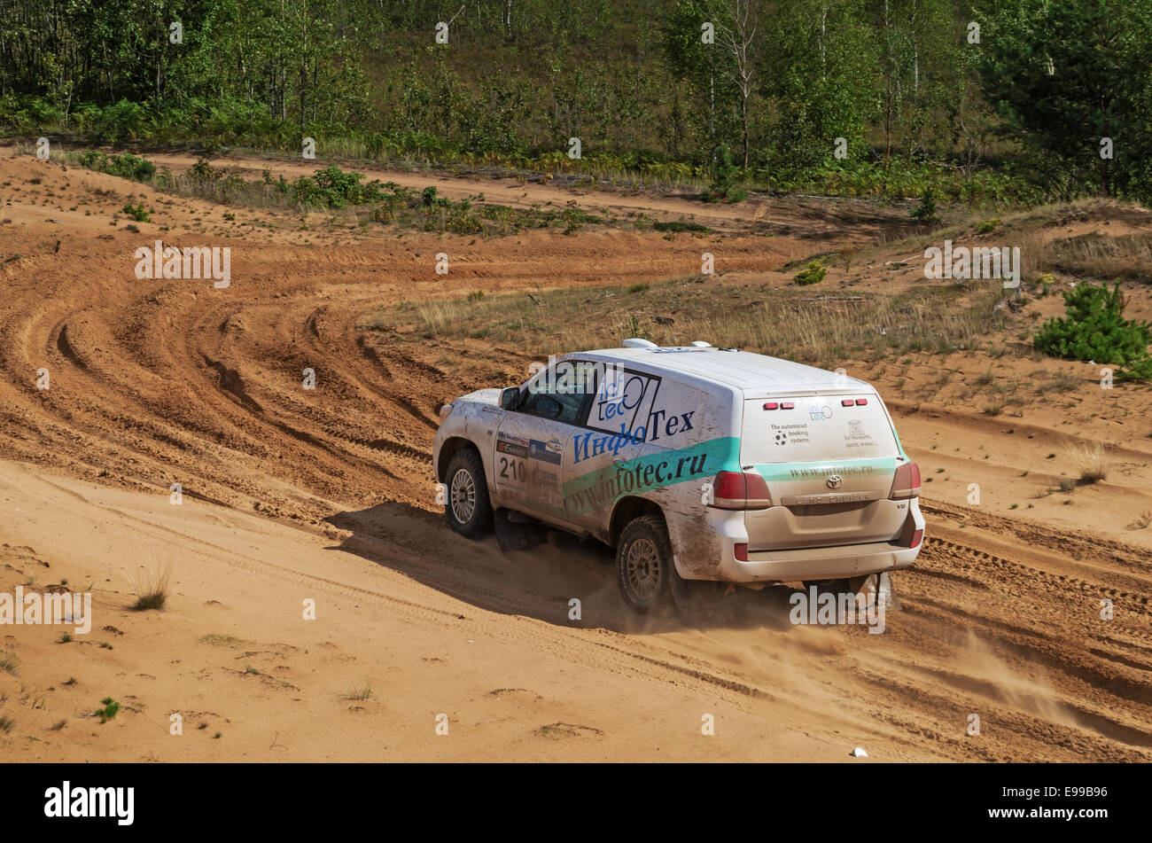 Races on a rally-raid on sandy dunes. Racing car number 210 Stock Photo ...