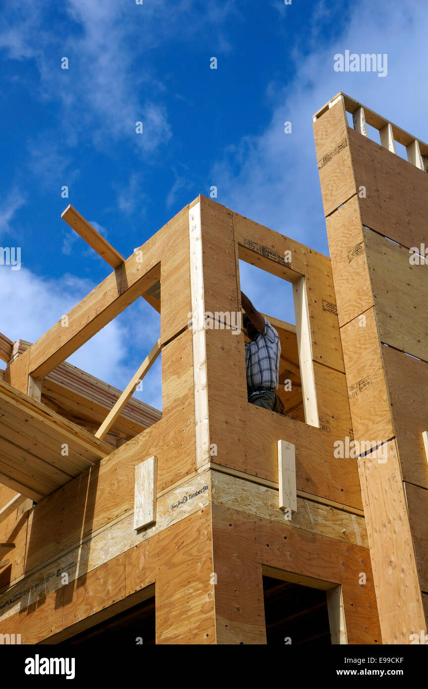 Man working on new wood frame house being constructed in, Vancouver, BC ...