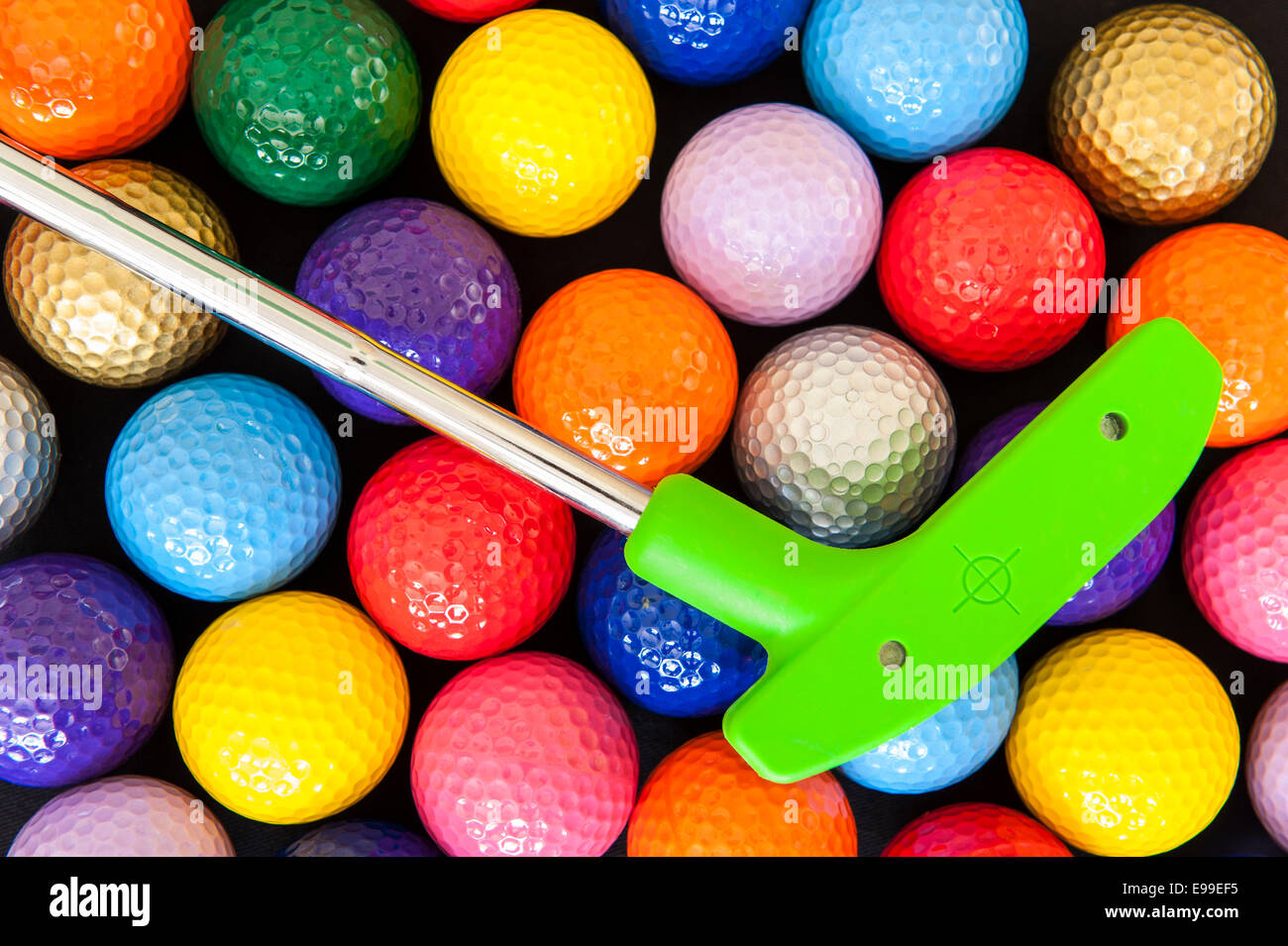 Green mini golf putter with balls of assorted colors Stock Photo - Alamy