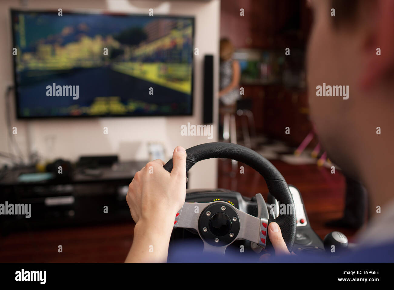 Man playing racing game with steering wheel simulator Stock Photo - Alamy