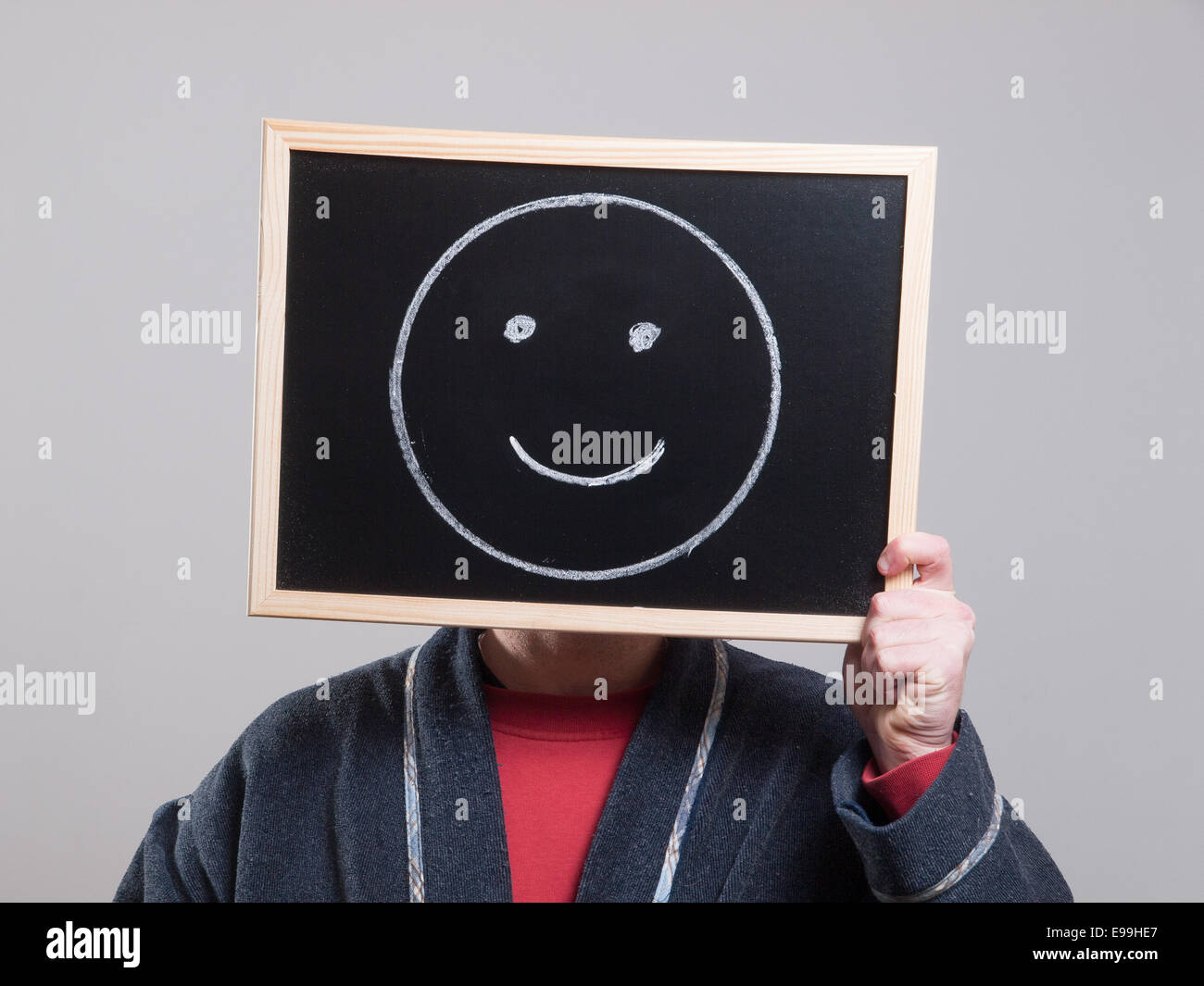 Man hiding his face with a billboard with a smiley face on it Stock ...