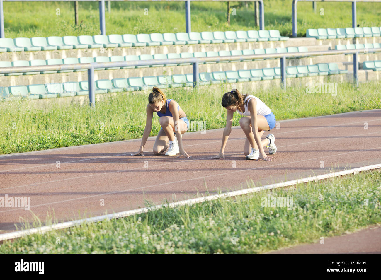 two girls running on athletic race track Stock Photo - Alamy