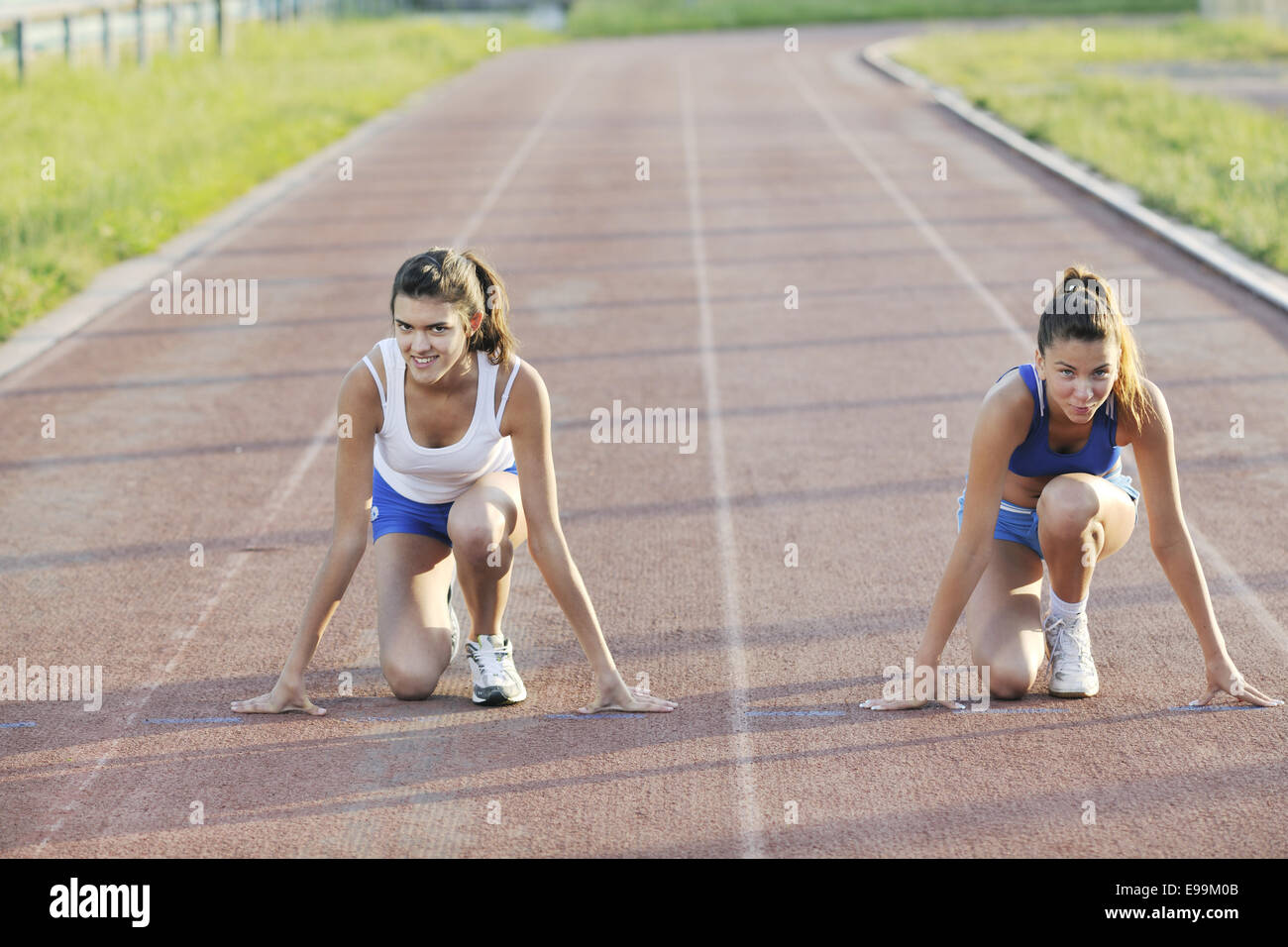 two girls running on athletic race track Stock Photo - Alamy