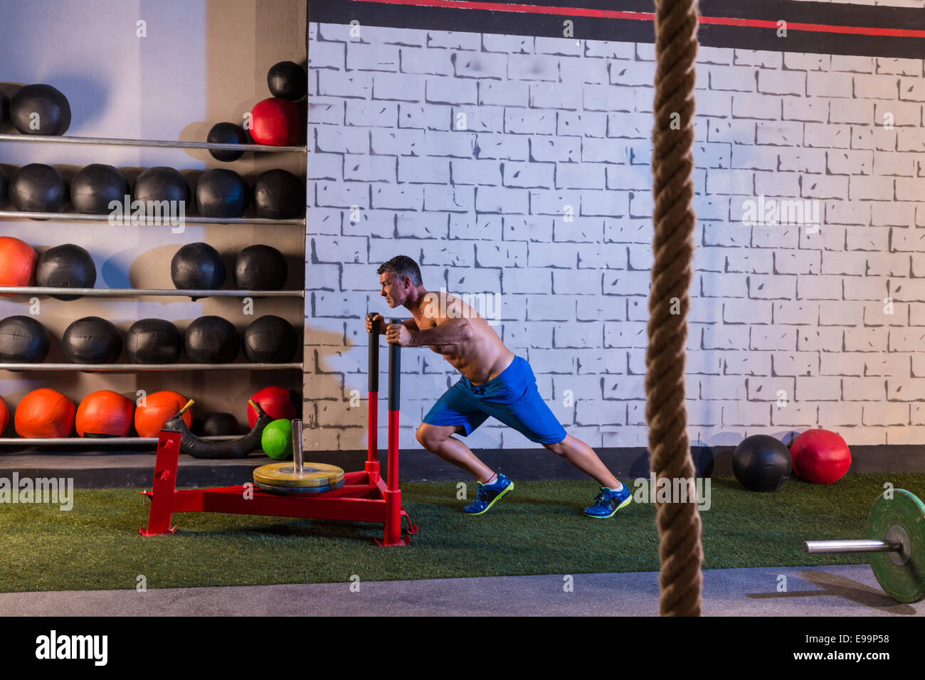 sled push man pushing weights workout exercise Stock Photo - Alamy