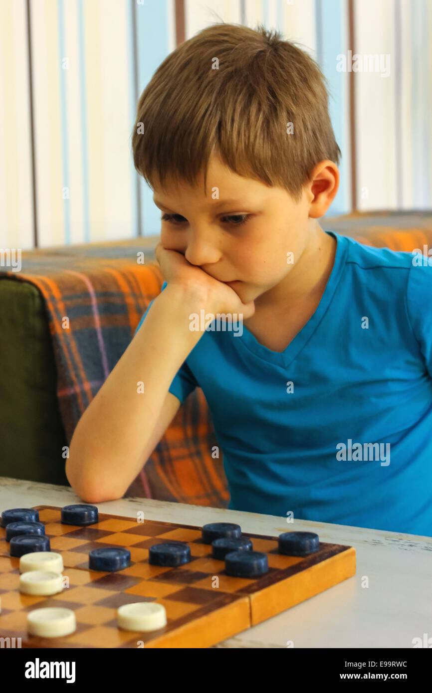 Pensive boy during a game of checkers Stock Photo - Alamy