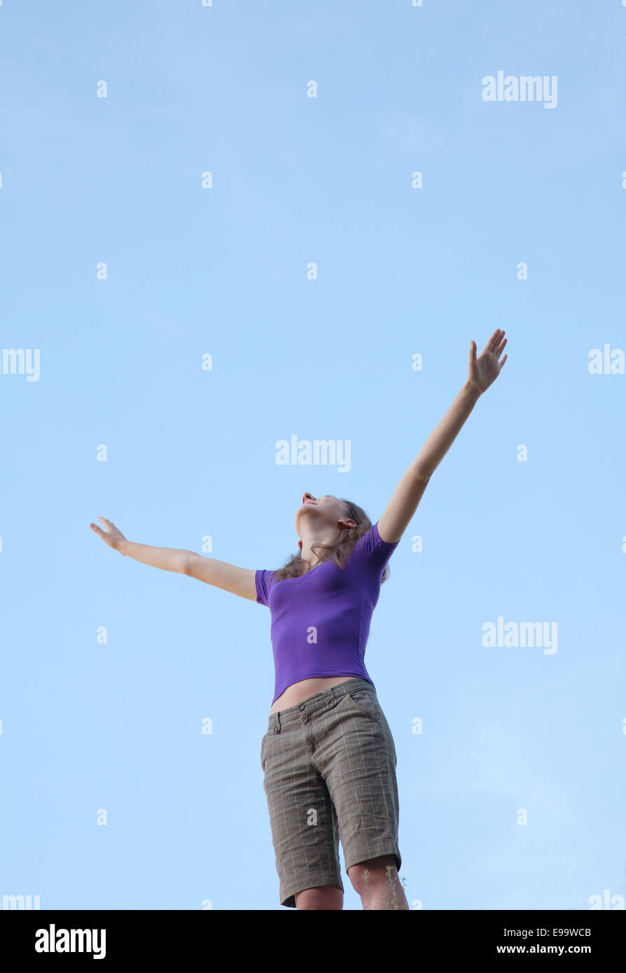 Young woman sitting with raised hands Stock Photo - Alamy