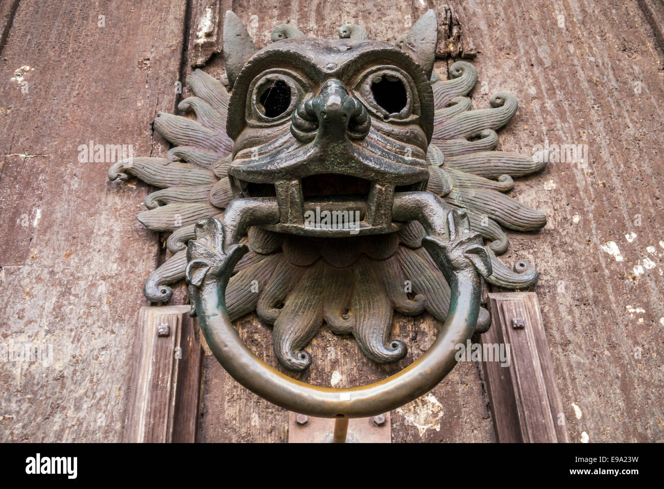 Large metal door knocker on old wooden door Stock Photo - Alamy