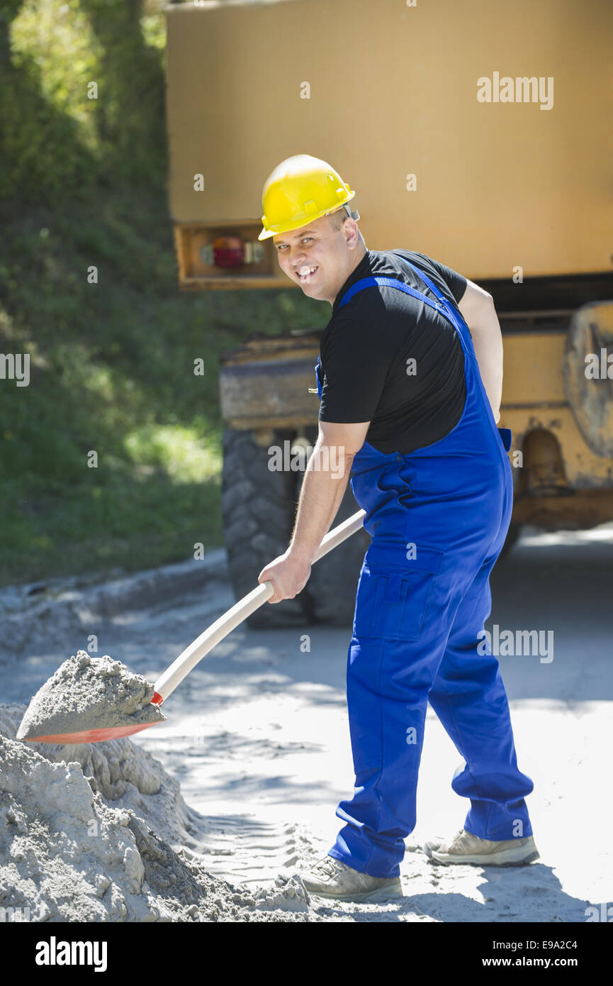 Construction worker with a shovel in hand Stock Photo - Alamy