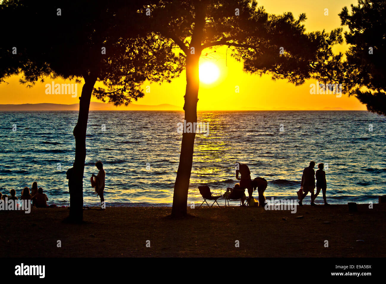 People silhouette on beach at sunset Stock Photo - Alamy