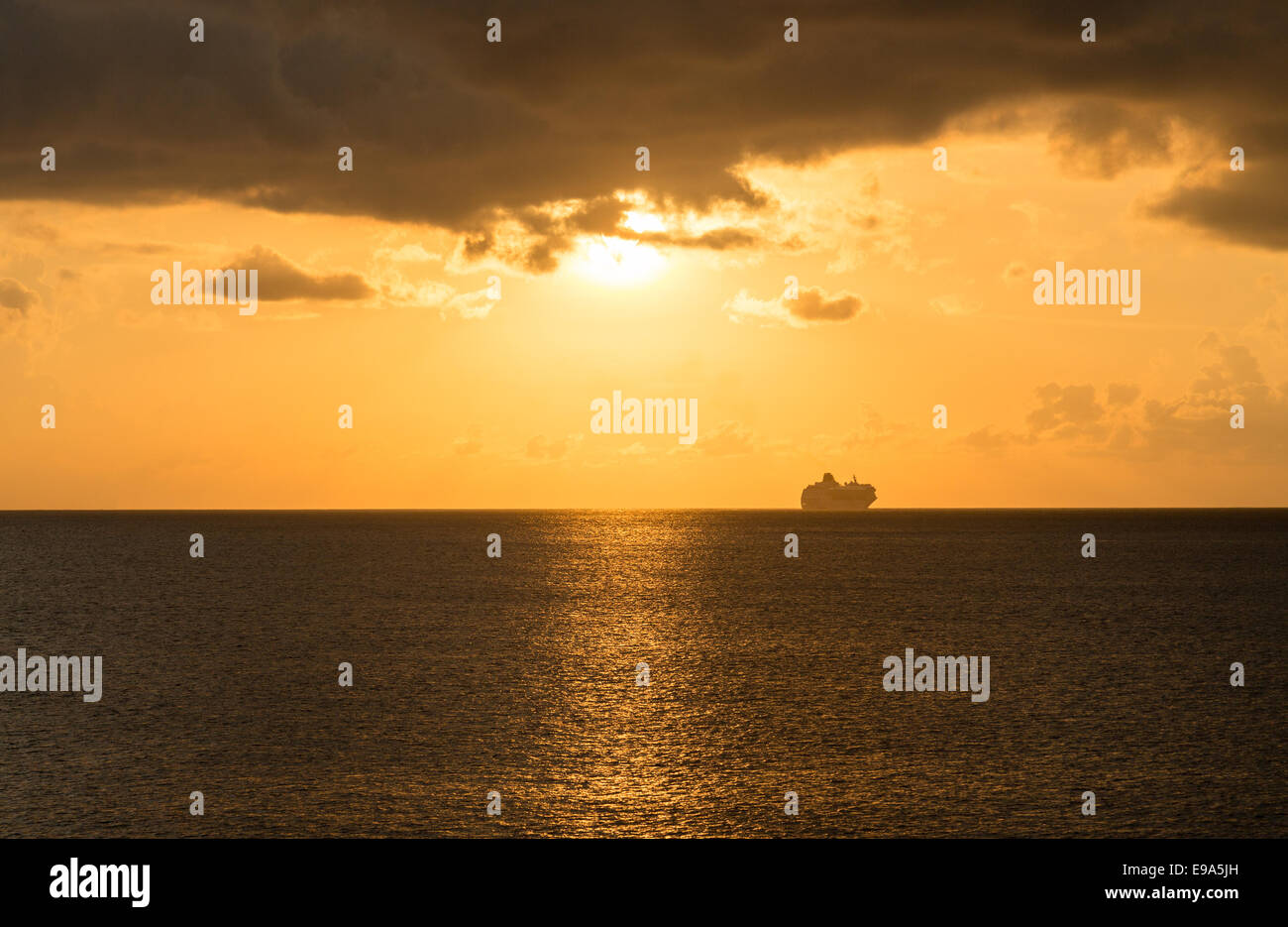 Cruise ship on horizon at sunset Stock Photo - Alamy