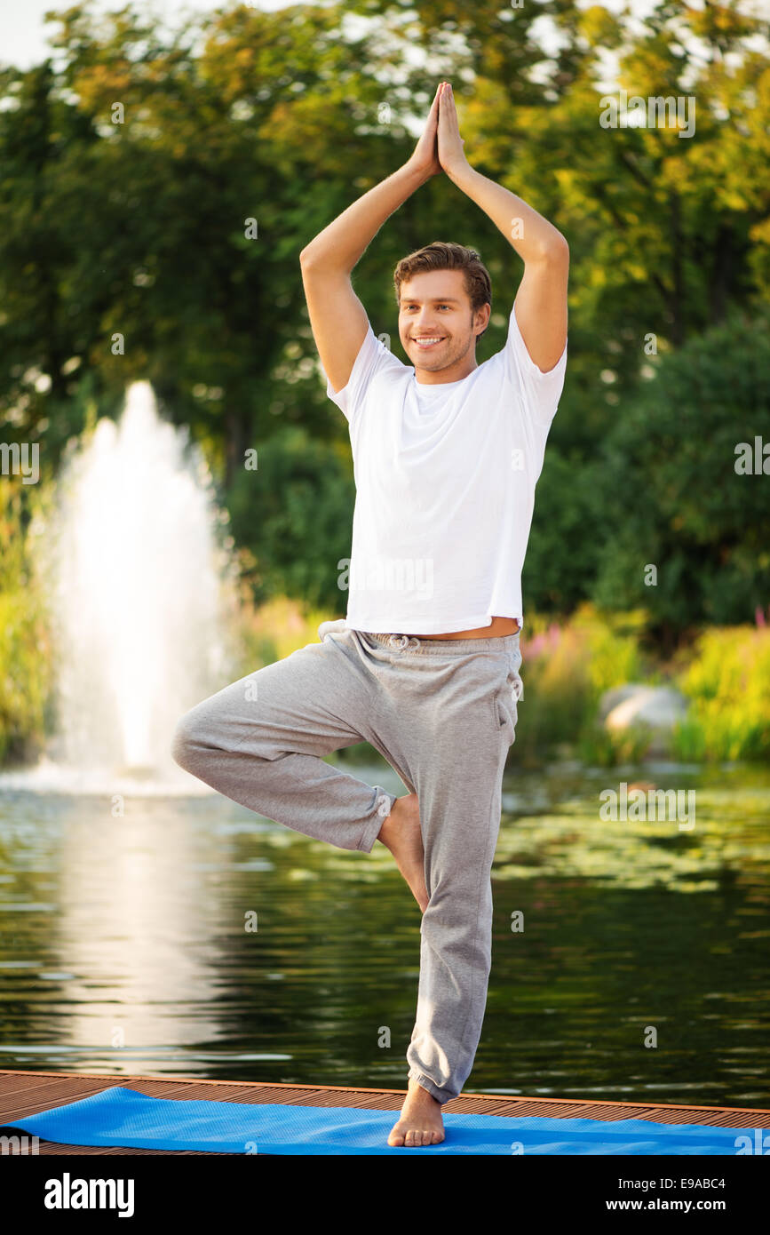 Yoga man doing tree pose Stock Photo - Alamy