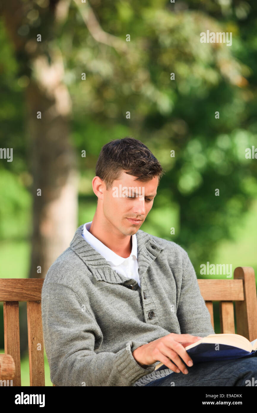 Young man reading his book on the bench Stock Photo - Alamy
